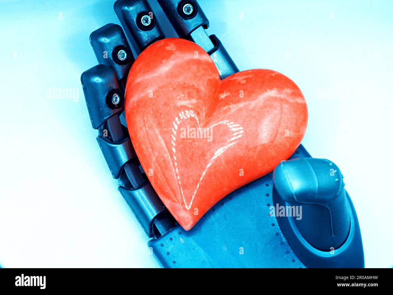Cyborg hand holding a human heart Stock Photo - Alamy