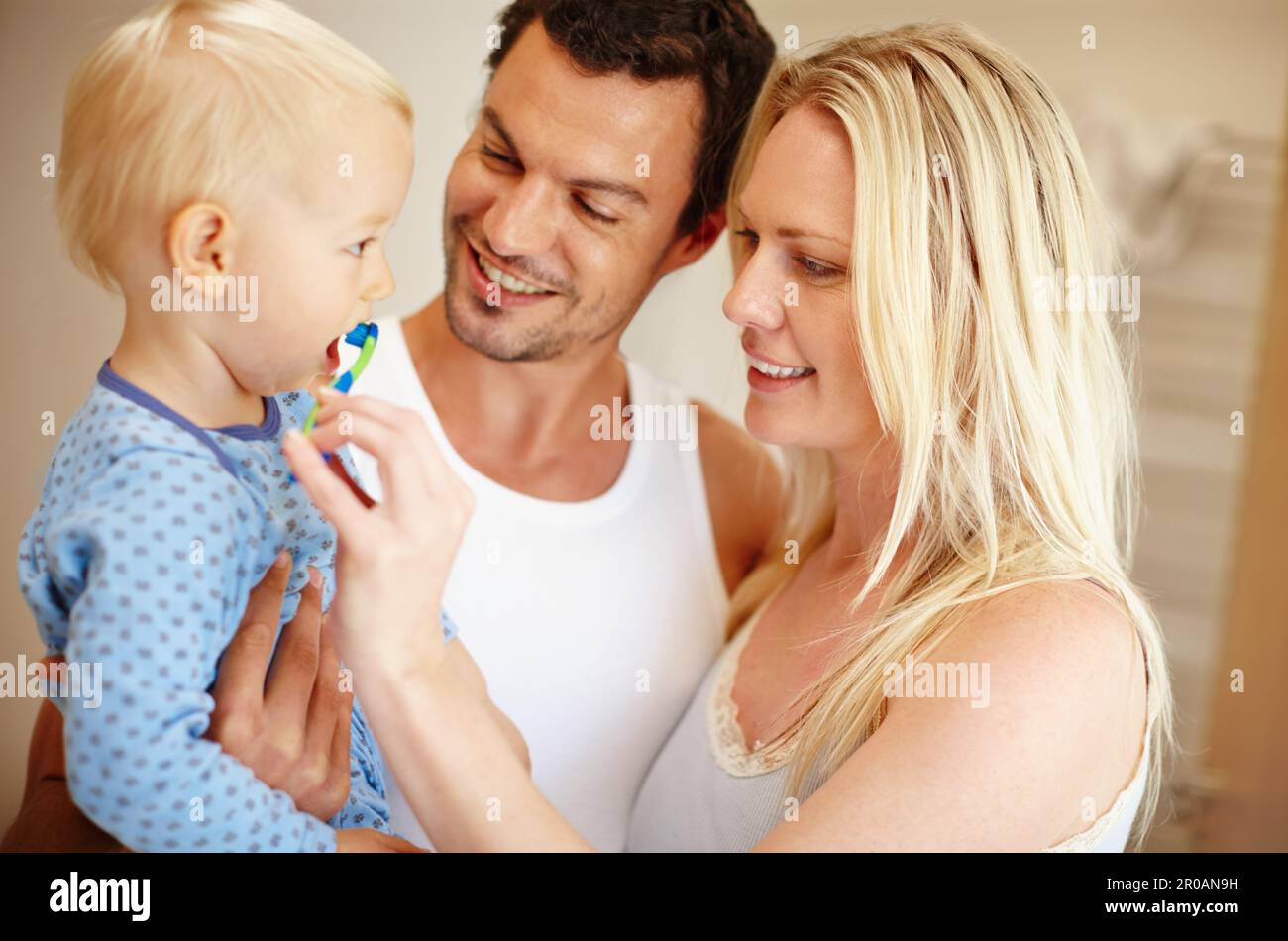 Taking care of the little ones teeth. A young mother and father ...
