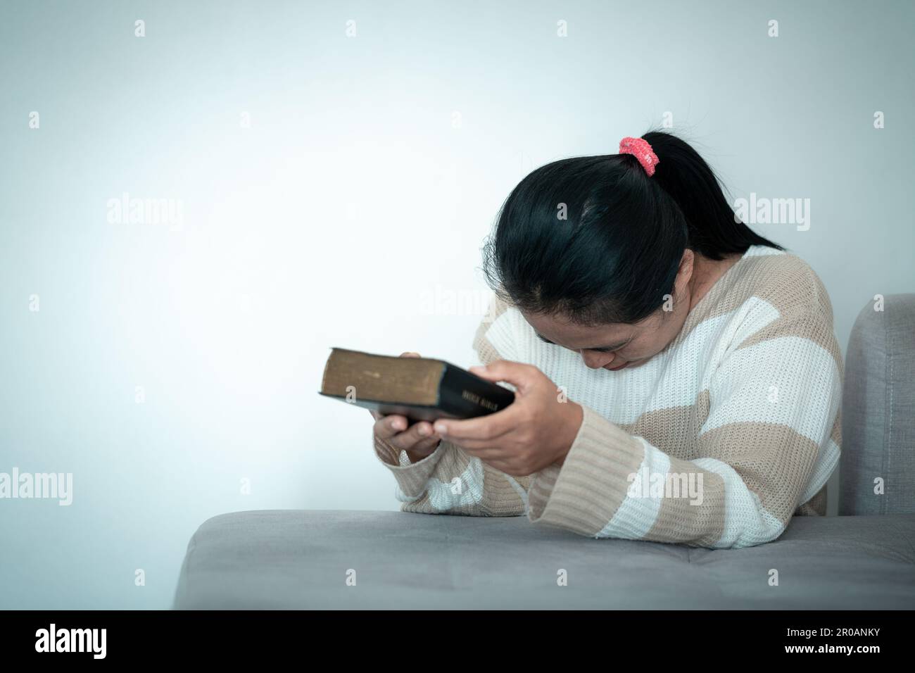 woman kneeling and praying in modern house at sunset time. Female ...