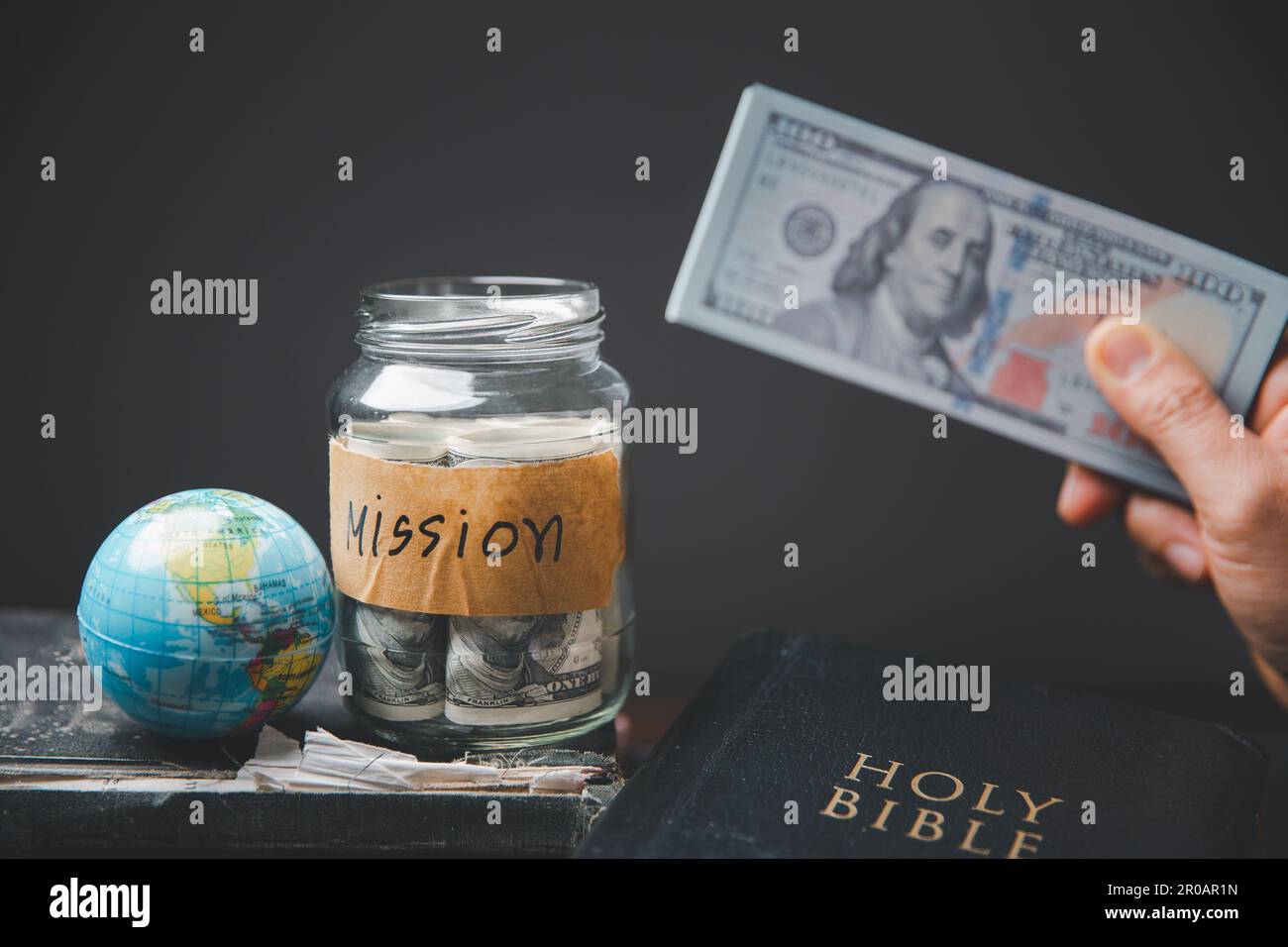 Saving jars full of money and globe with Holy Bible for mission ...