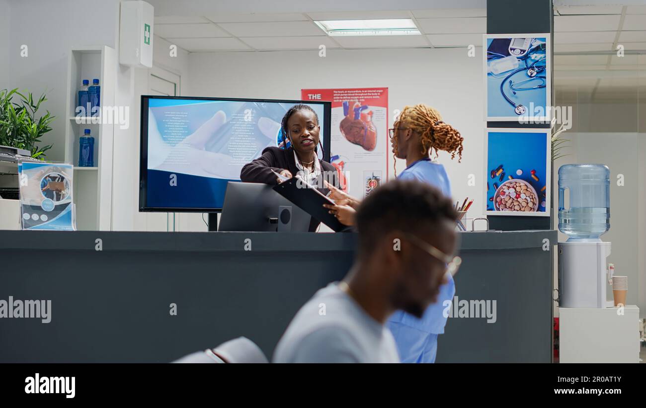 Professional medic giving advice to sick patient in facility hallway ...