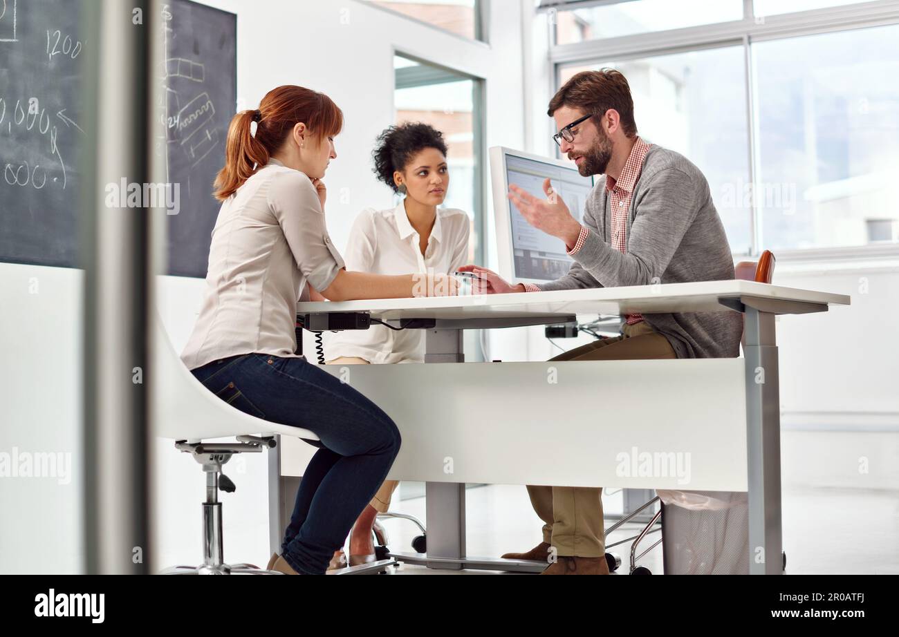 Teamwork gets business done. A group of businesspeople going over some ...