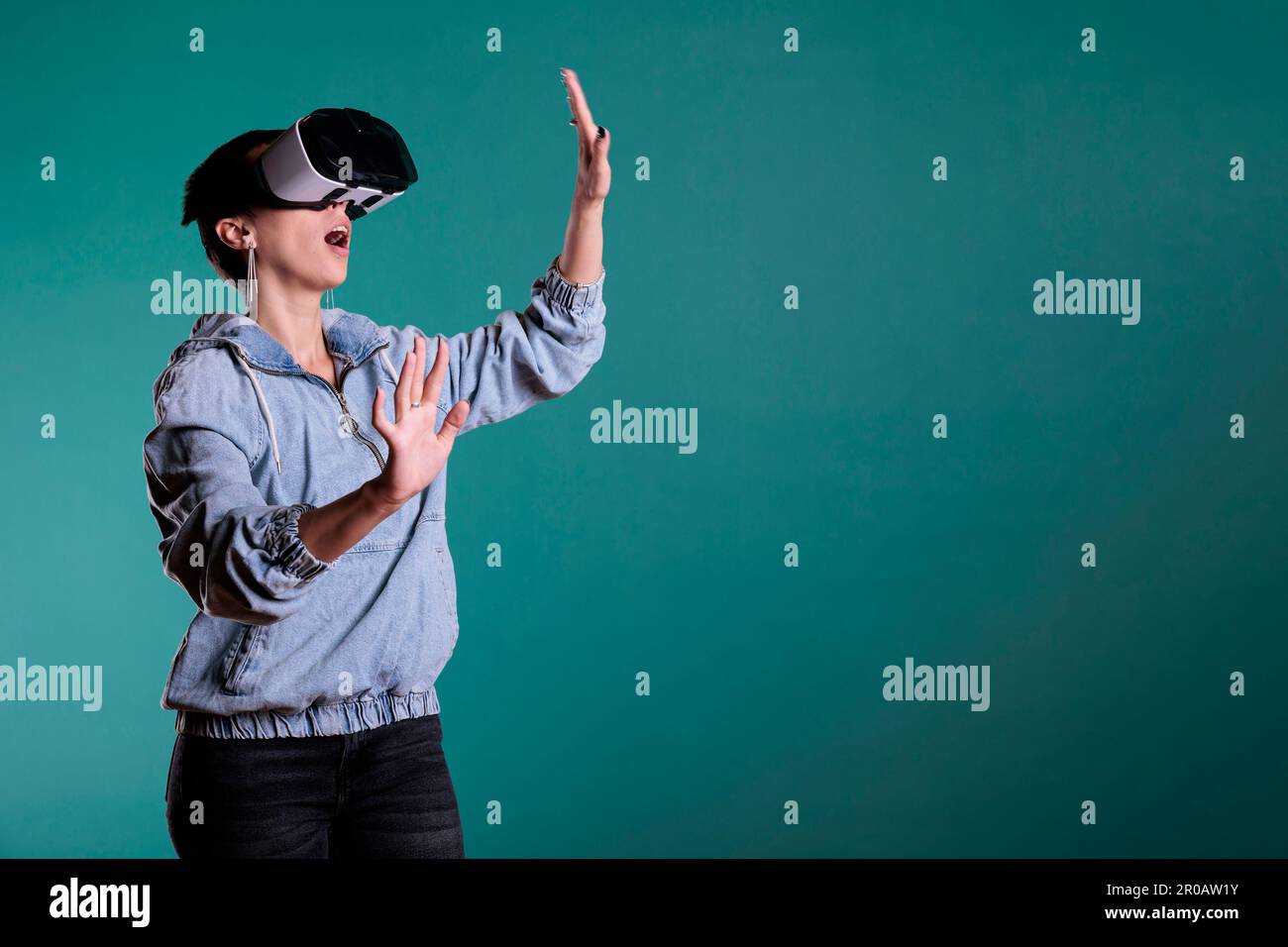 Cheerful woman wearing virtual reality headset in front of camera ...