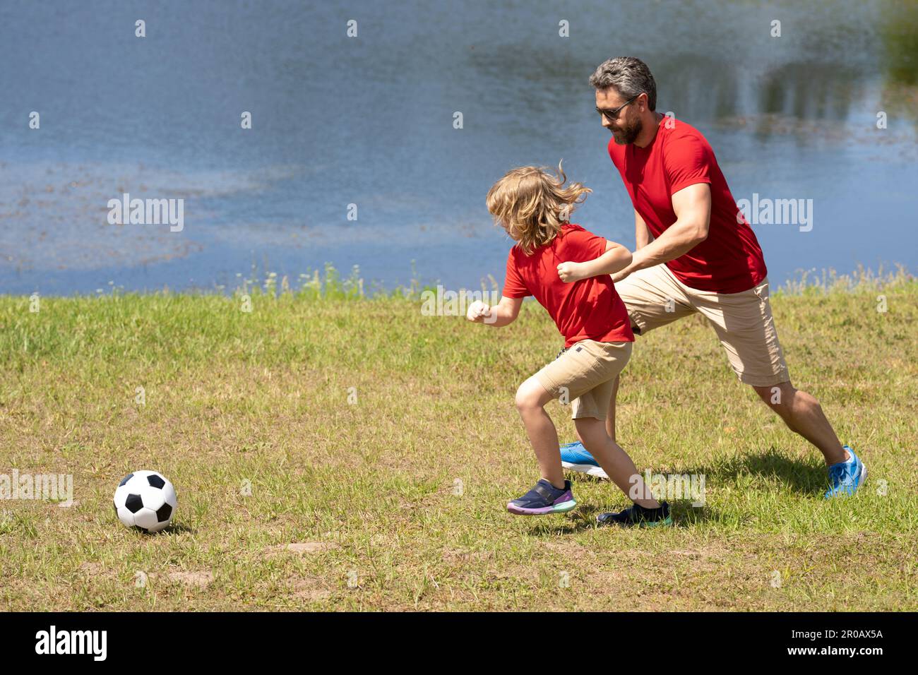 Father and son playing football together. Dad with kid spend hours ...
