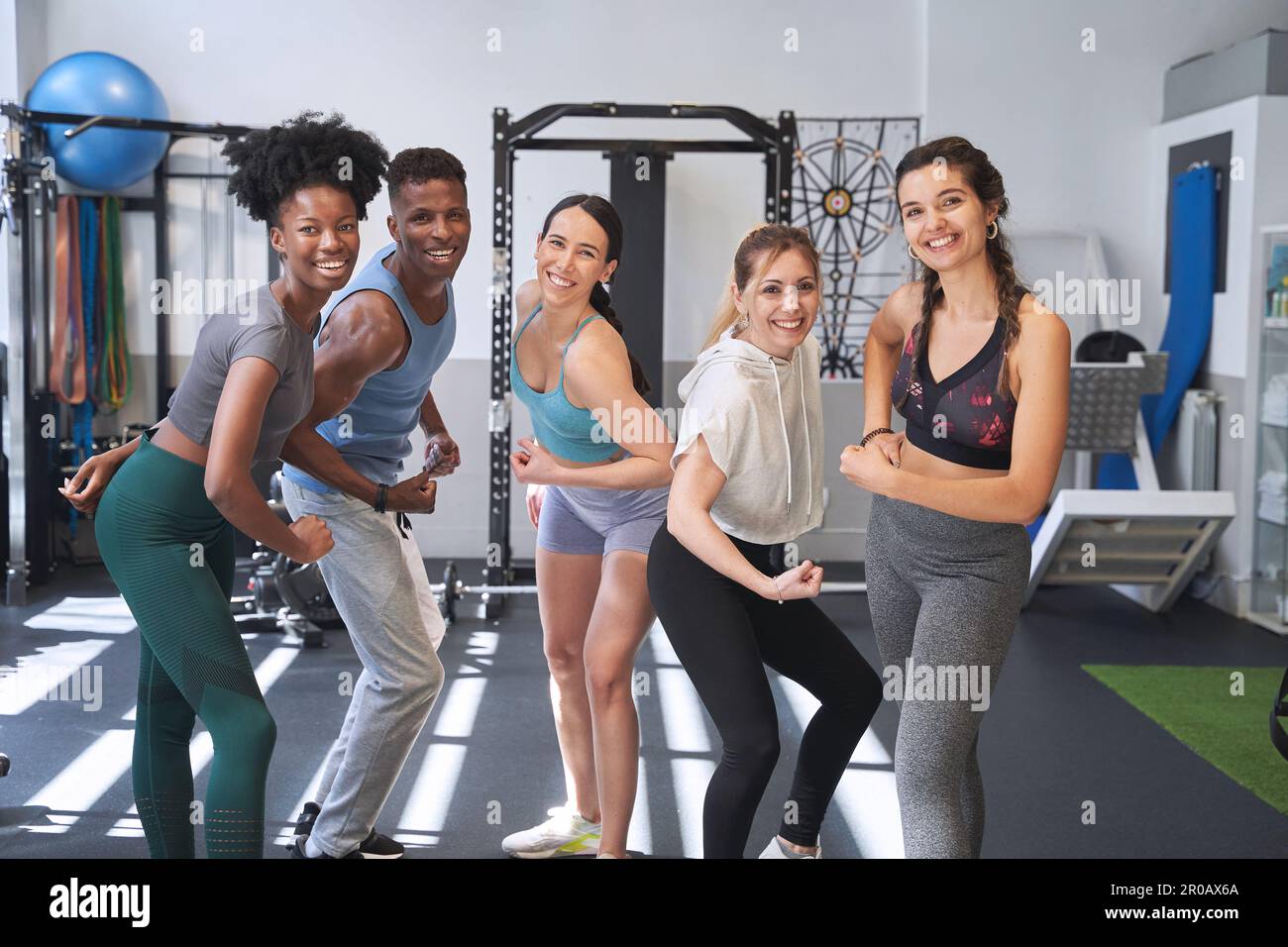 Group of sporty people showing arm muscles while posing in the gym ...