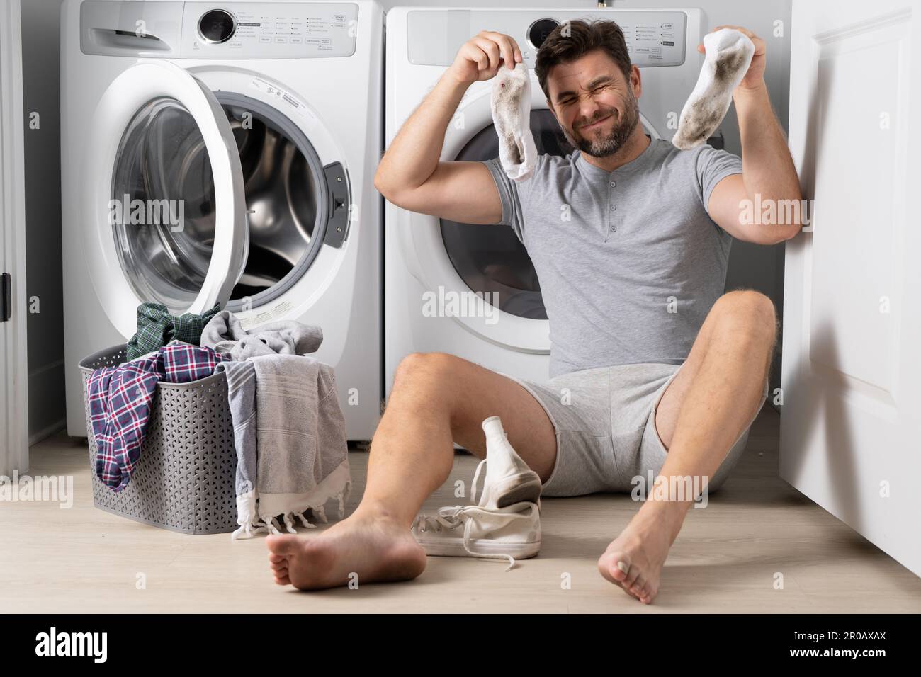 Man with clothes near washing machine. Laundry cleaning. Housework ...