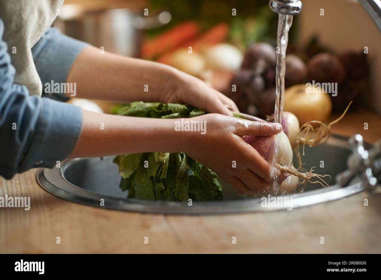 Washing them off before its time to cook. a woman washing vegetables in ...
