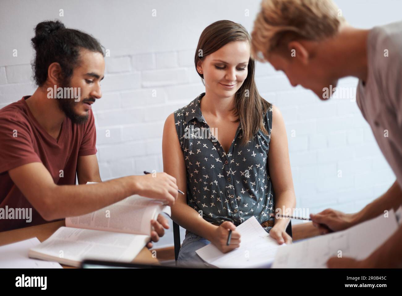 Comparing class notes. a group of university students studying together ...