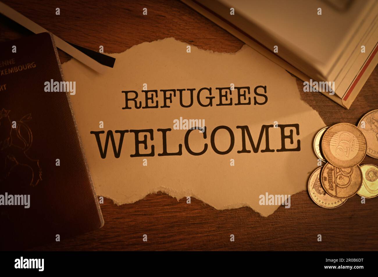 A close-up image of a stack of coins beside the phrase "Refugees ...