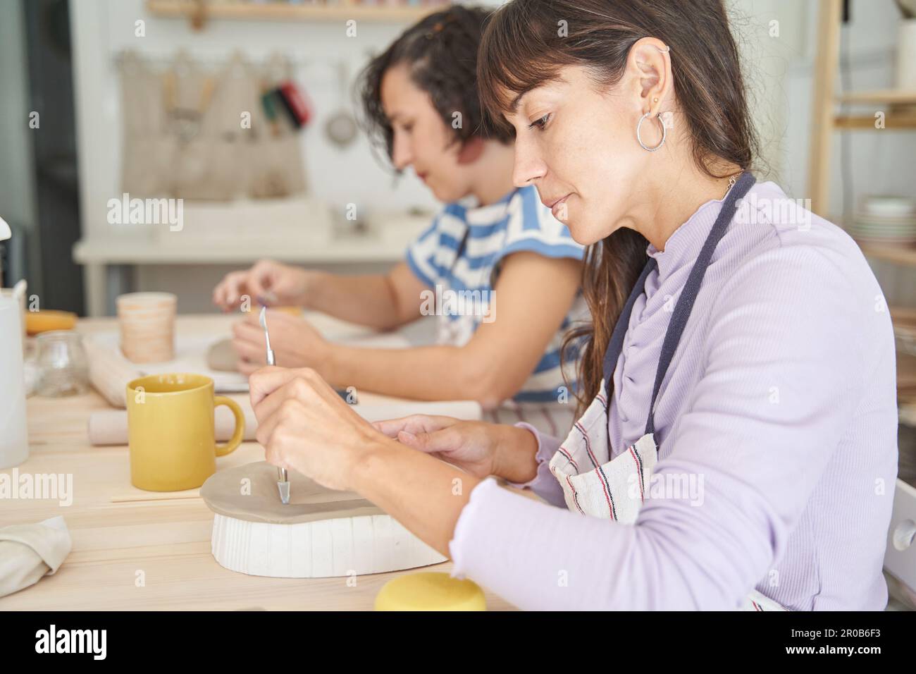 Women making handmade pottery in a pottery class. Handicraft and ...