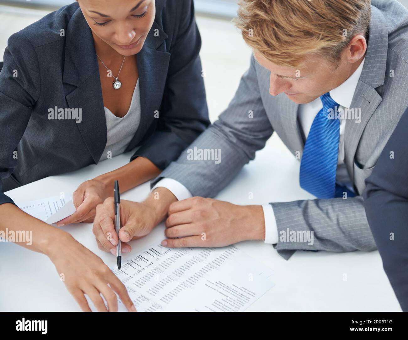 These plans look good. businesspeople looking over documents in a lobby ...