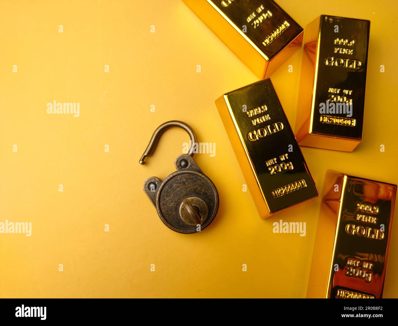 Vintage padlock with gold bar on a yellow background Stock Photo - Alamy
