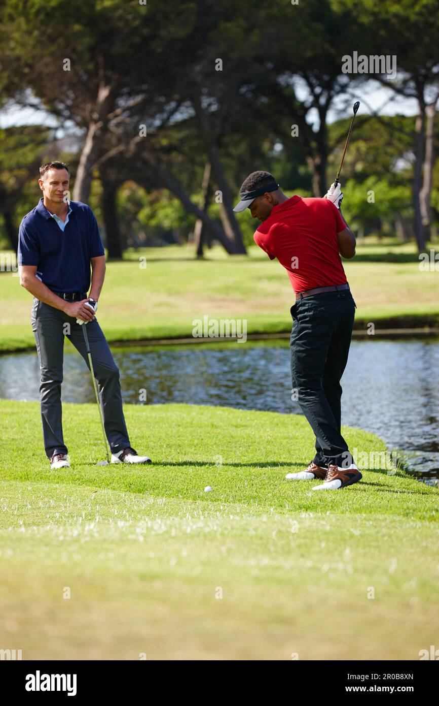 Time for a big swing. two men playing a round of golf together Stock ...