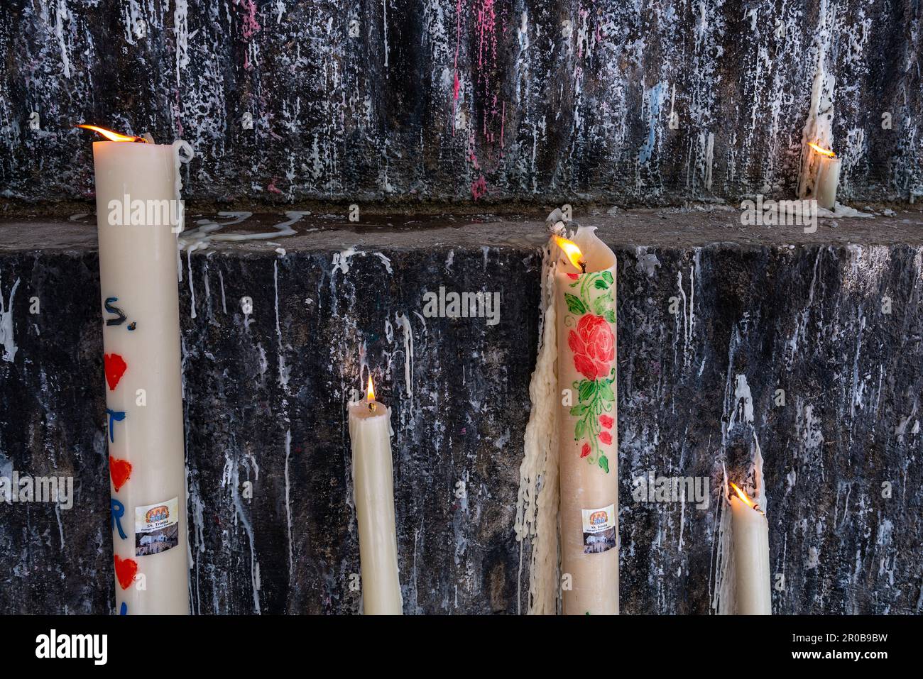 Religious candles lit for devotion by pilgrims who arrive to honor the ...