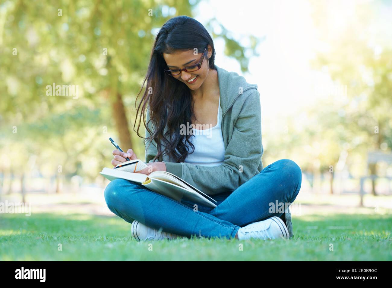 Preparing for exams. A student studying her textbook in the park Stock ...