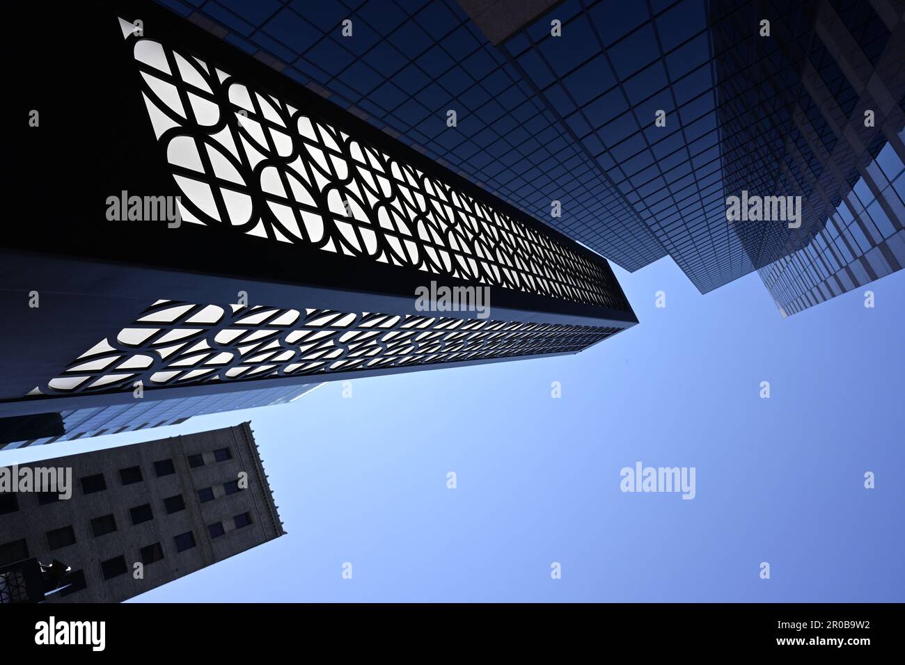 Three tall buildings illuminated by the sun in a bright blue sky ...