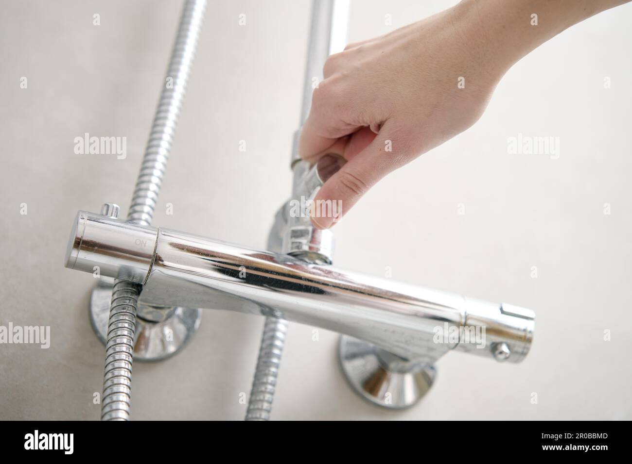 Female hand turn on shower faucet. Modern shower set in bathroom ...