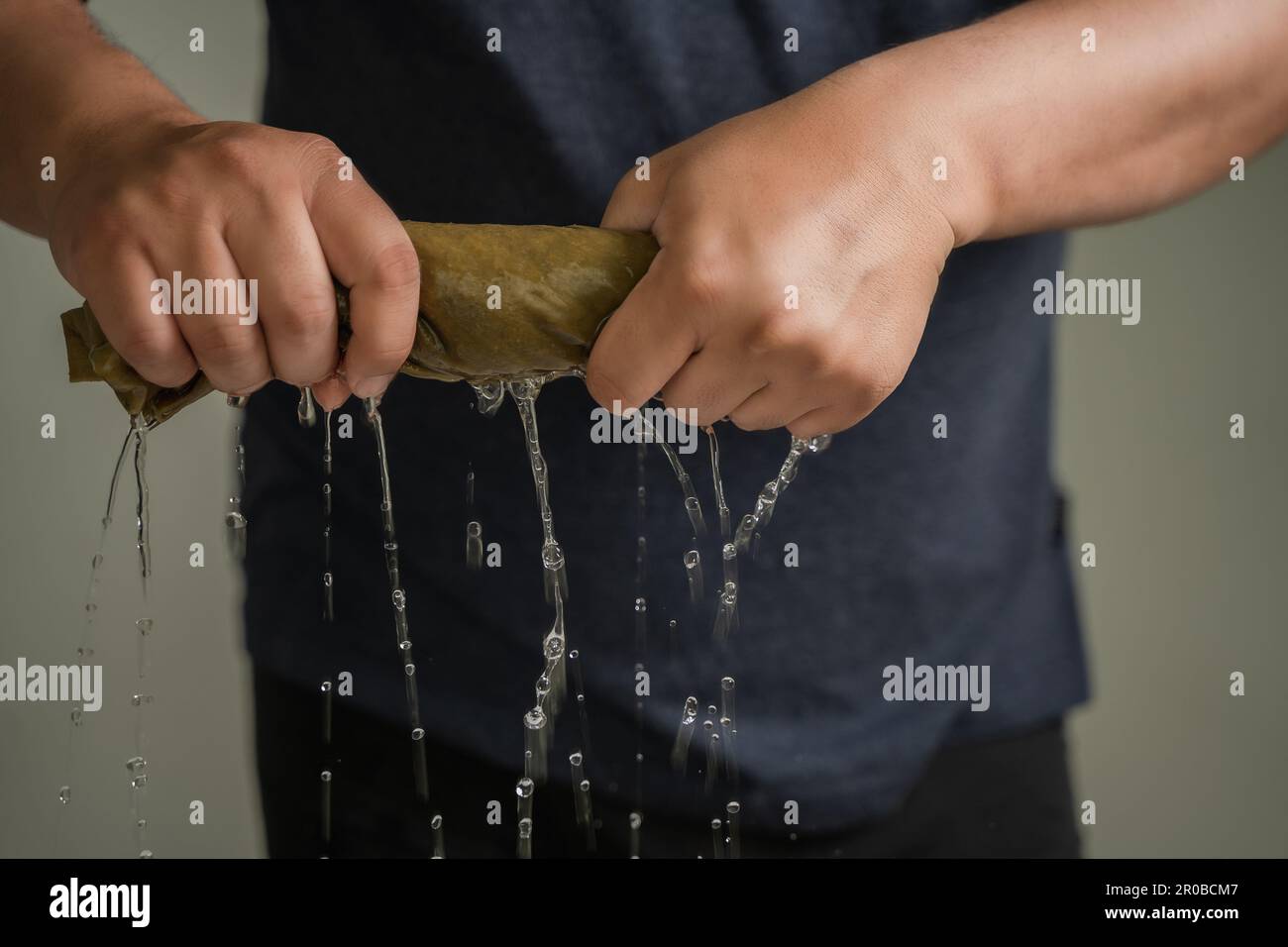 Man's hands squeeze wet fabric, outdoor drop water, short squeeze Stock ...