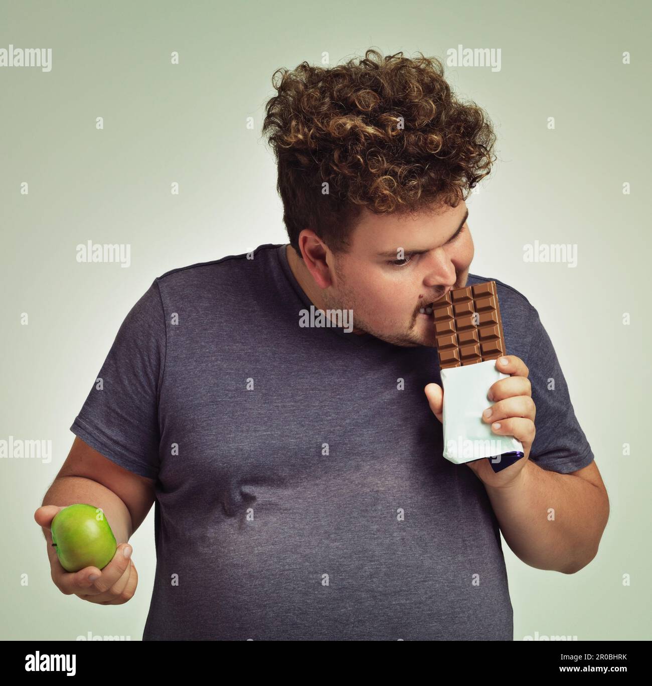 Sorry Mr Apple - you lose this round. an overweight man taking a bite ...