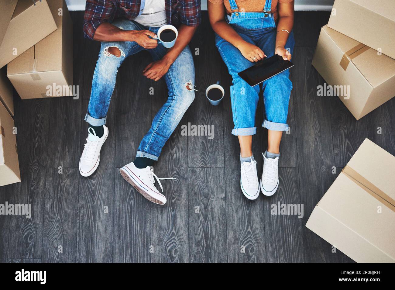 Tablet, coffee and couple moving with boxes planning their new house ...