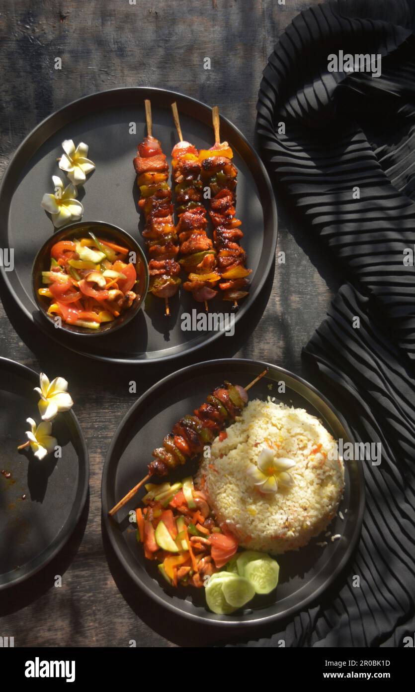 Chicken saslik with fried rice and salad Stock Photo - Alamy