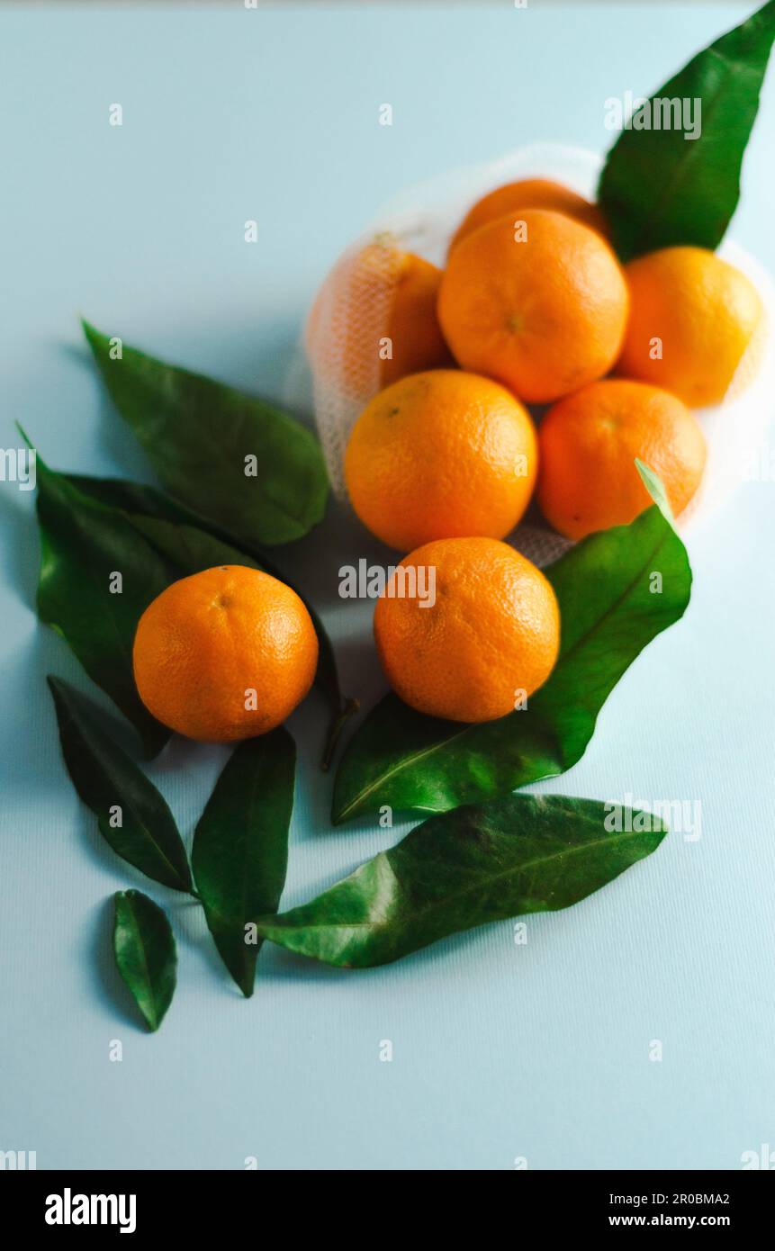 tangerines in an eco-bag and scattered near with leaves Stock Photo - Alamy