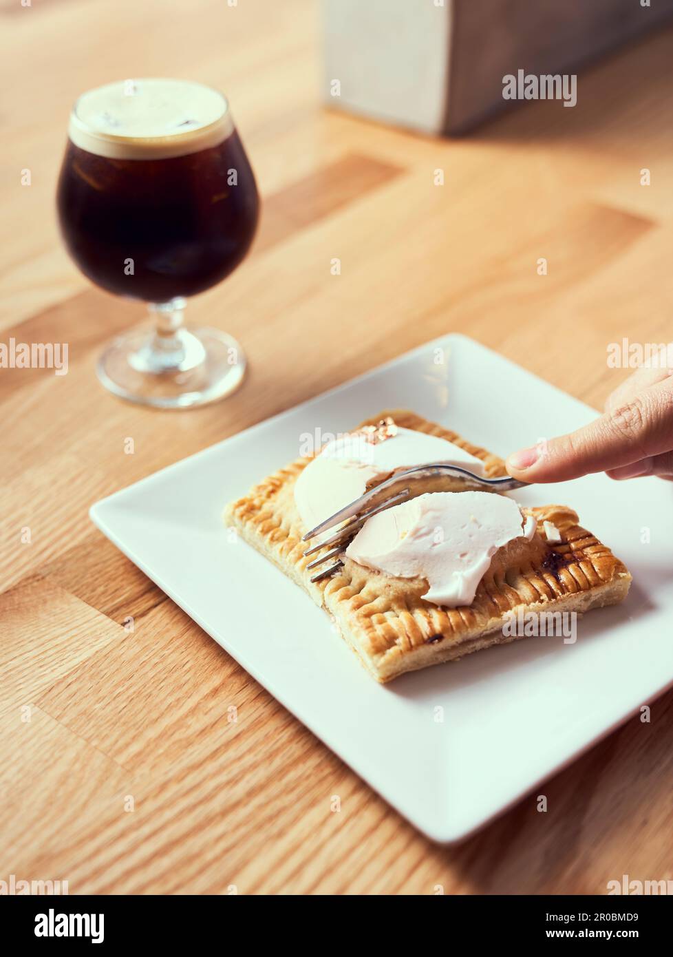 A pop tart pastry being cut and served with nitro cold brew Stock Photo ...
