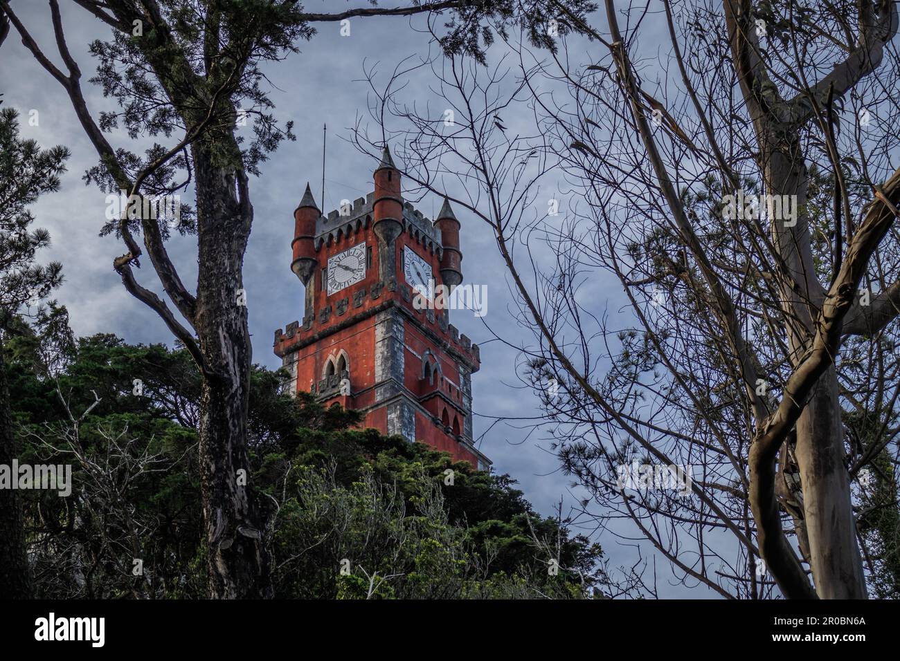 Red clock tower of the Pena Palace in Sintra, Portugal, surrounded by ...