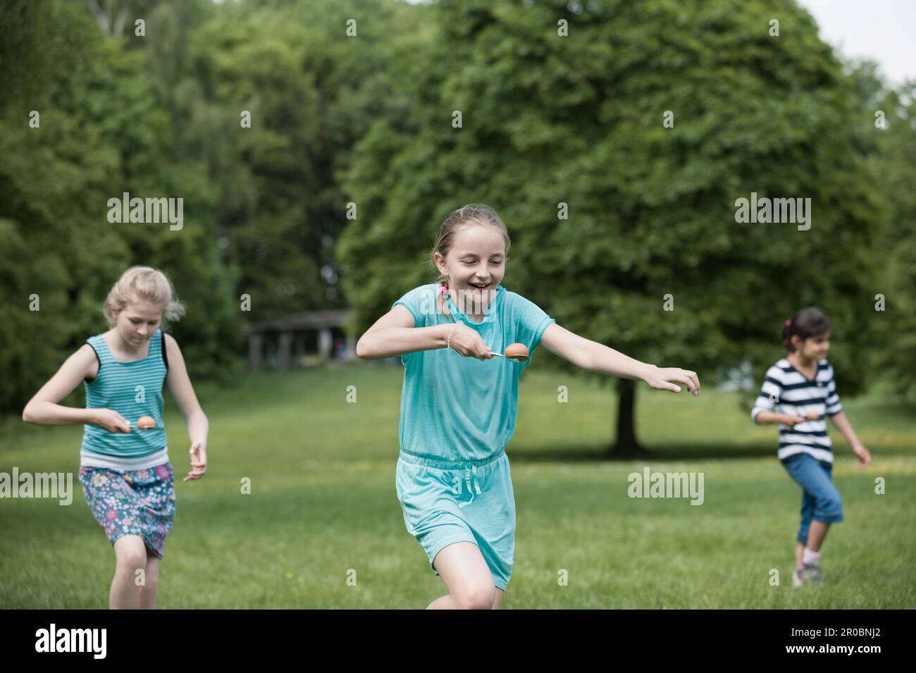 Group of girls competing in an egg-and-spoon race in a park, Munich ...