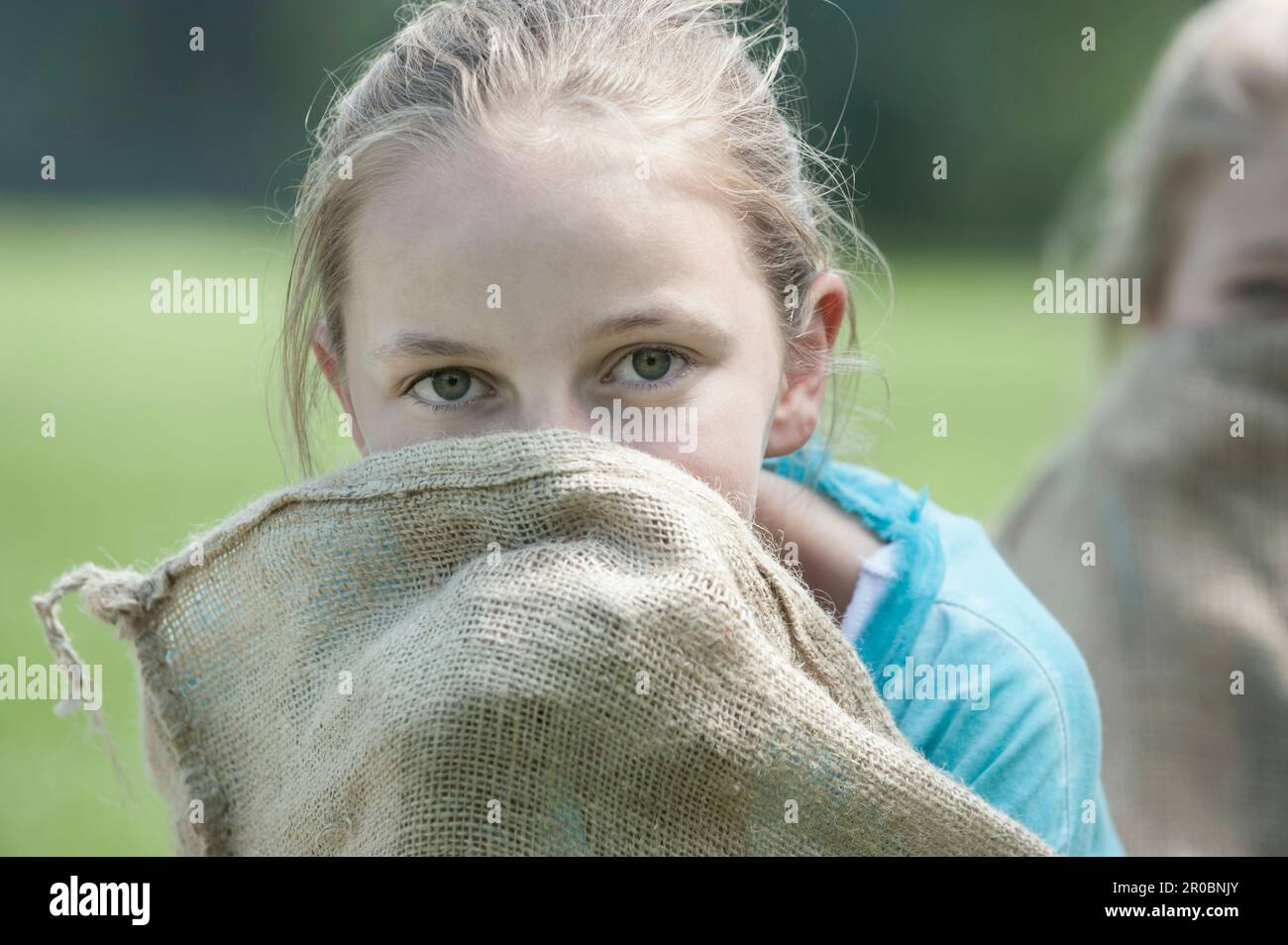 Close-up of girls hiding face in sack after sack race, Munich, Bavaria ...
