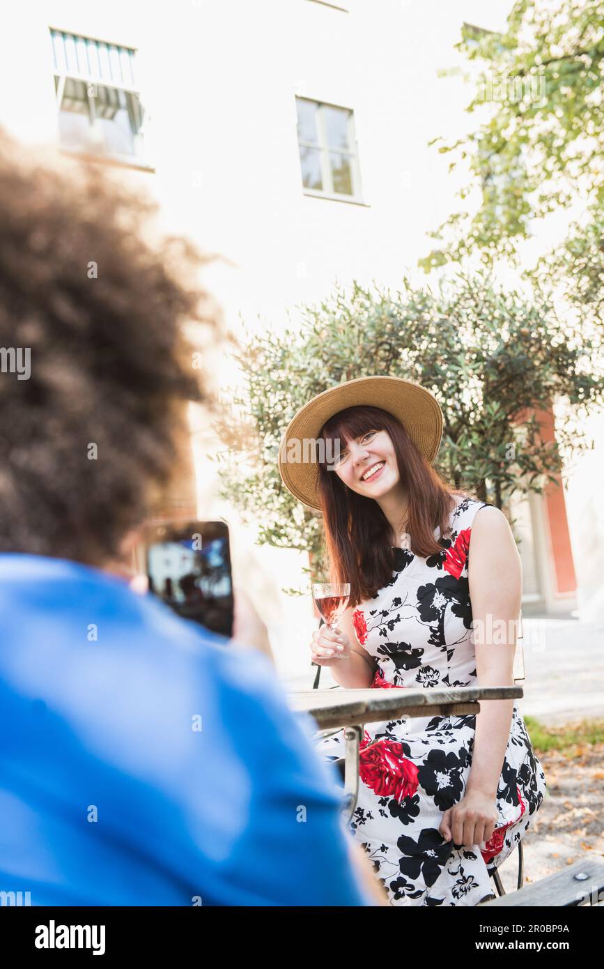 Man photographing his girlfriend using mobile phone camera at outdoor ...