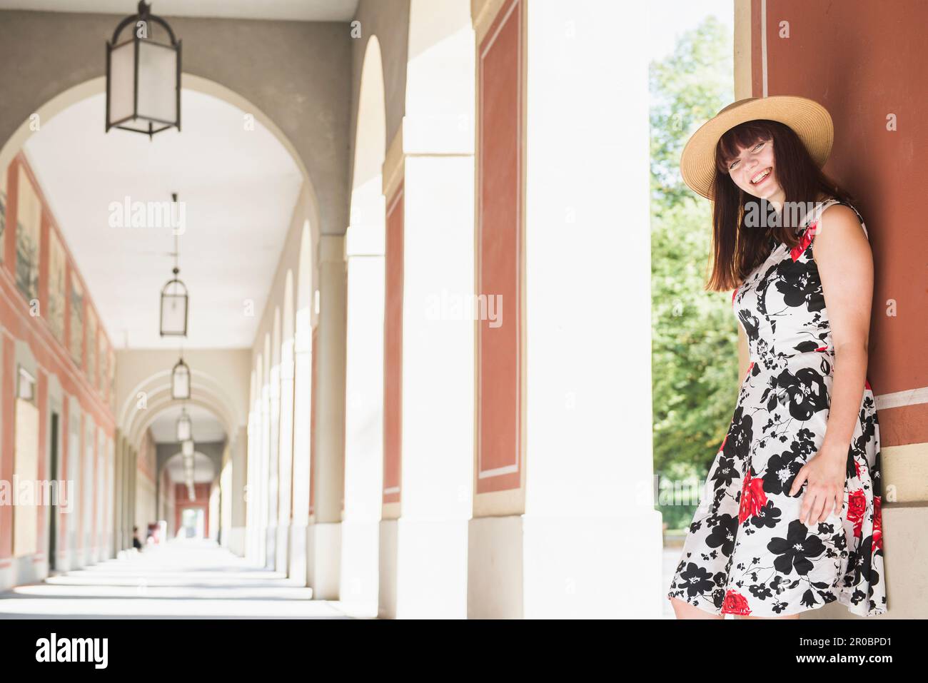 Beautiful woman leaning on the wall of archway Stock Photo - Alamy