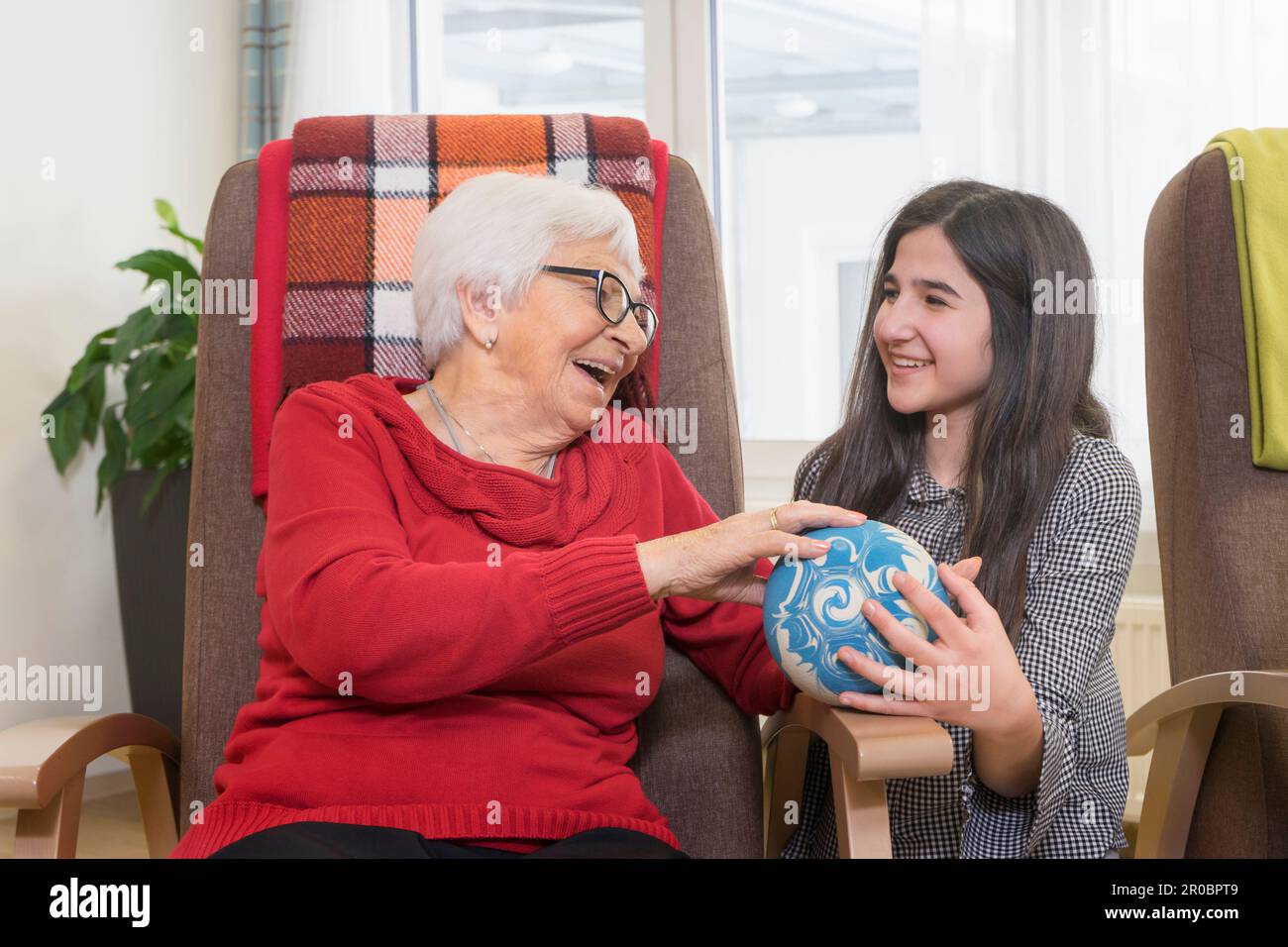 Girl playing bowling with senior woman in rest home Stock Photo - Alamy