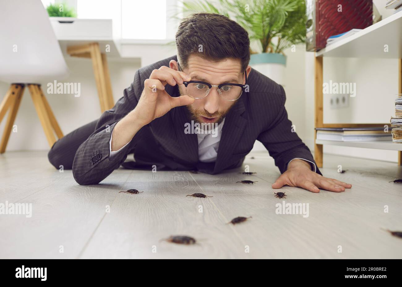 Shocked young man looking at lots of roaches crawling everywhere on the ...