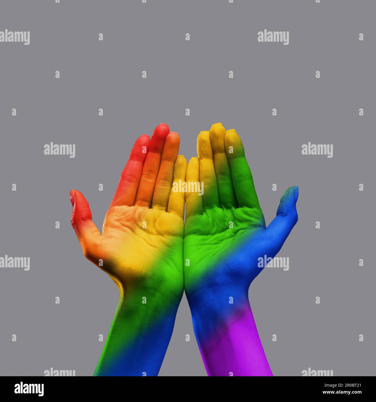 Human hands with open palms and rainbow lights on it over grey ...