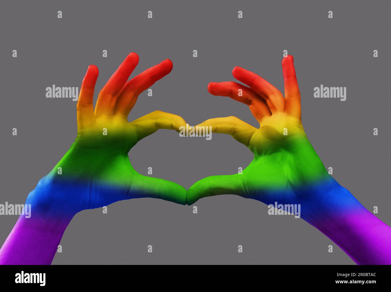 Human hands with rainbow light on it showing heart shape over grey ...