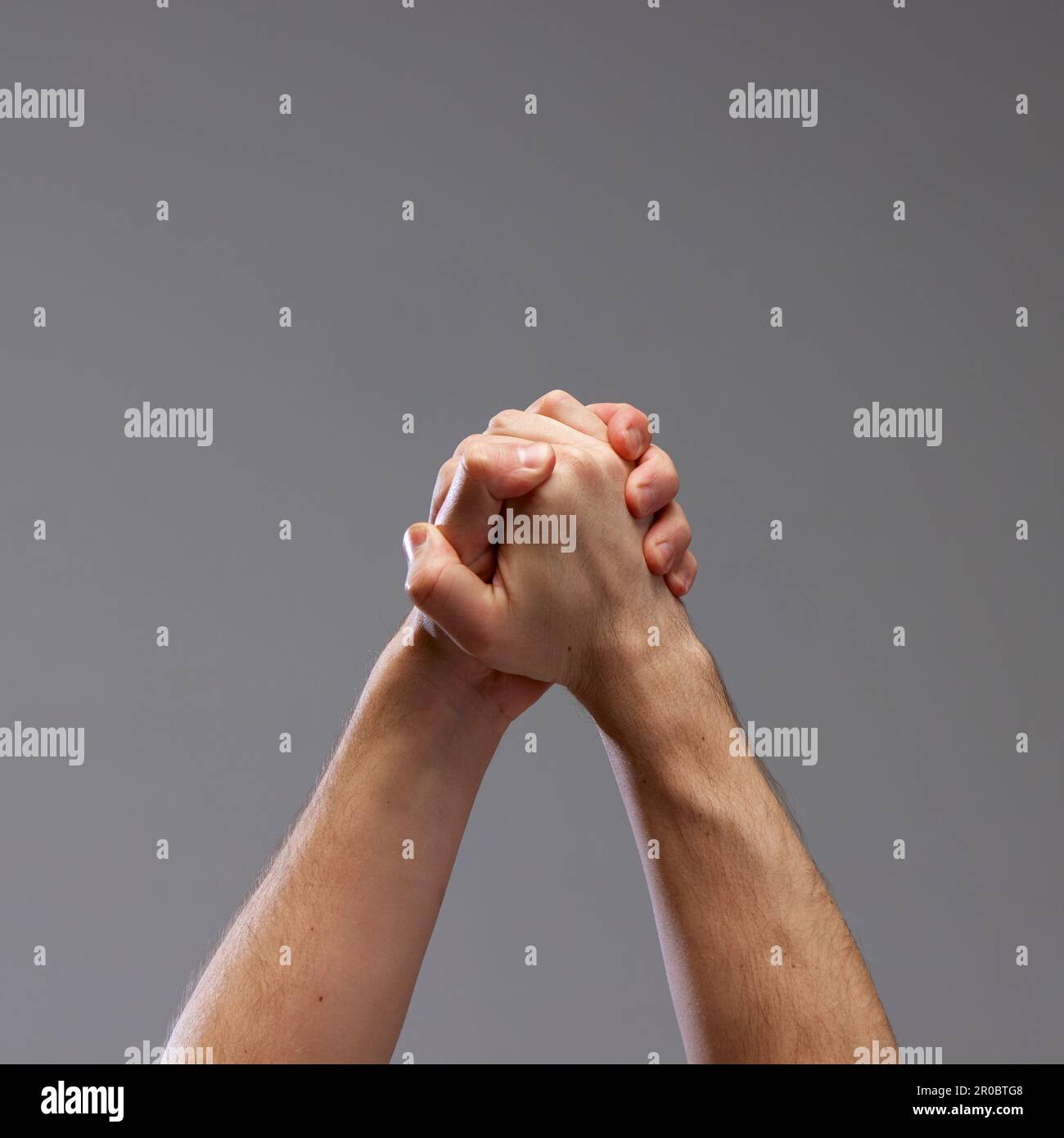 Male hands holding against grey background. Giving support, acceptance ...
