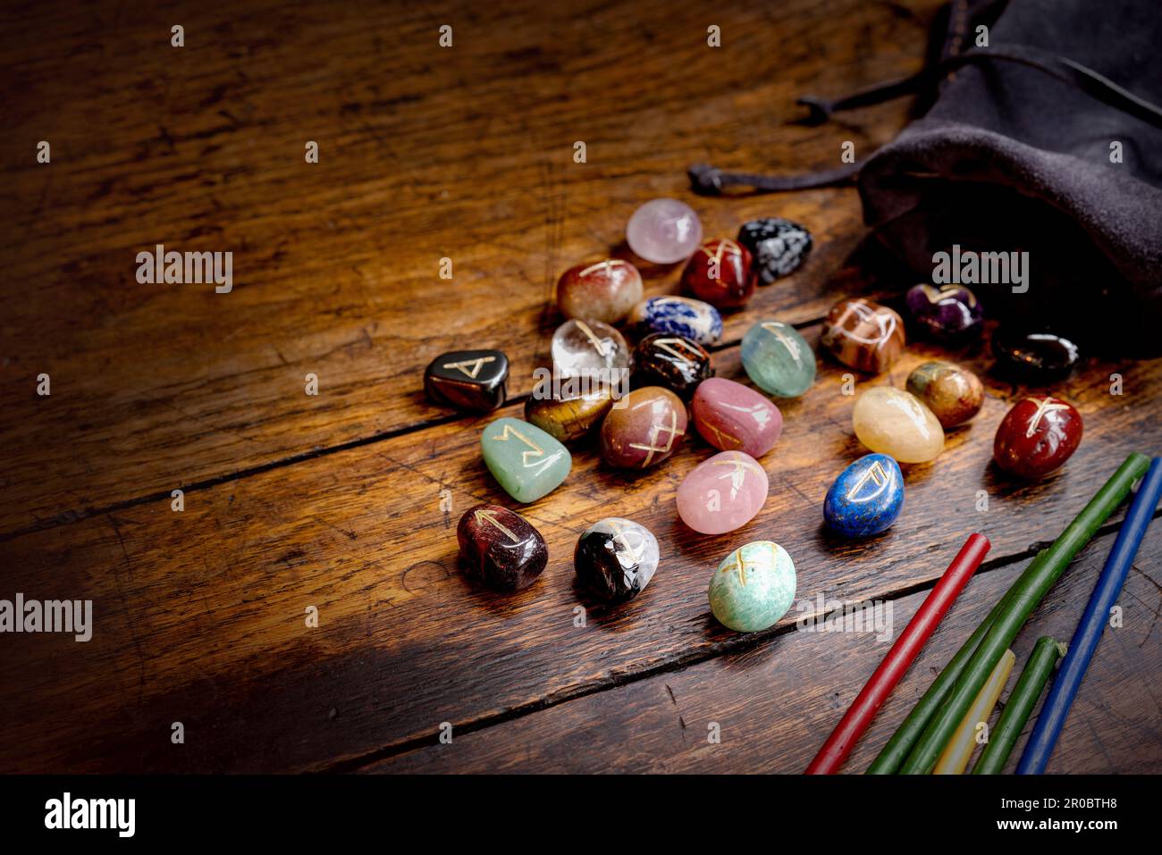Runestones on wooden table. Divination items. Runes, candles Stock ...