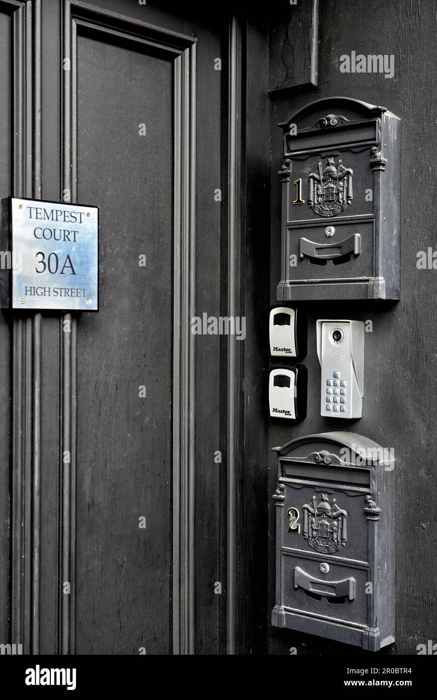 Vintage letter box with coat of arms countered against modern intercom ...
