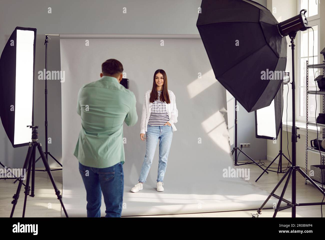 Male photographer shooting model in studio with with professional equipment Stock Photo - Alamy