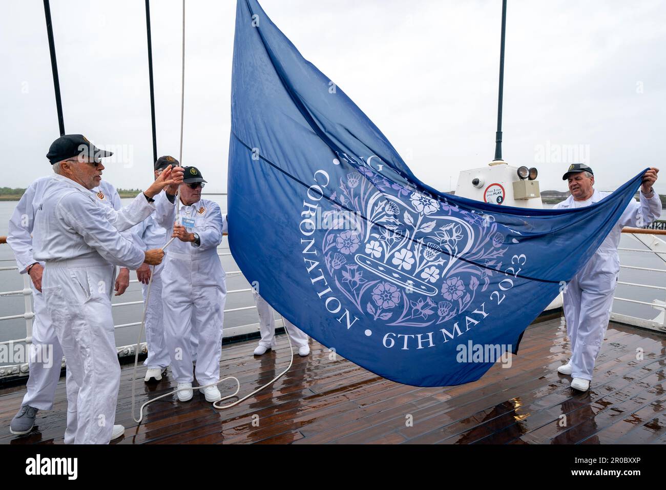 Royal Yachtsmen, known as 'Yotties', raise the Coronation flag on their ...