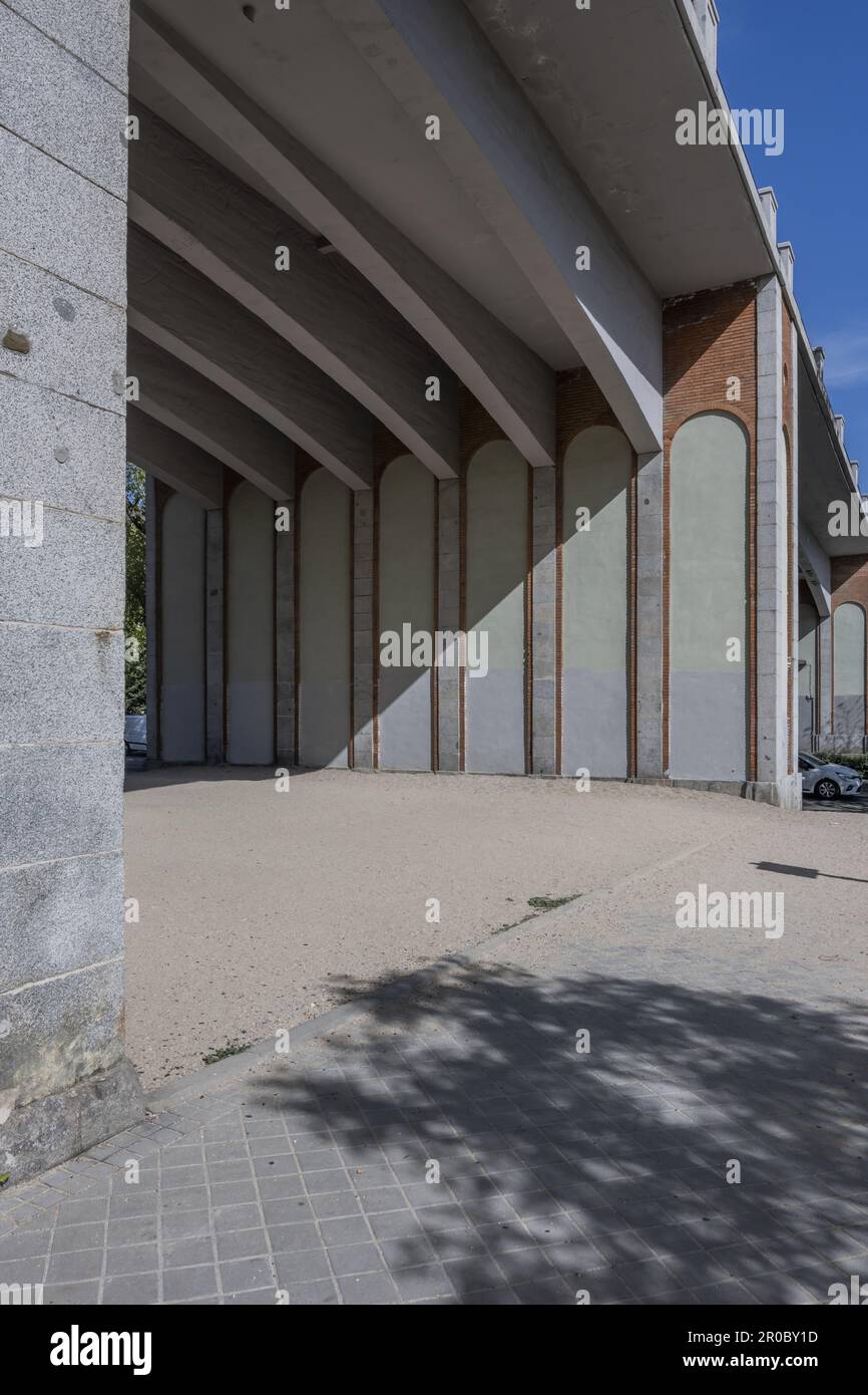 An urban corner with sand on the ground under the walls of a bridge ...