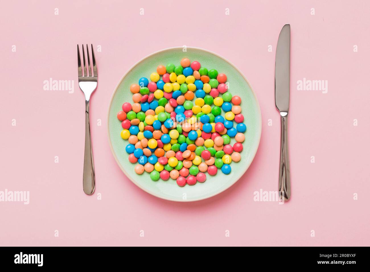 cutlery on table and sweet plate of candy. Health and obesity concept ...