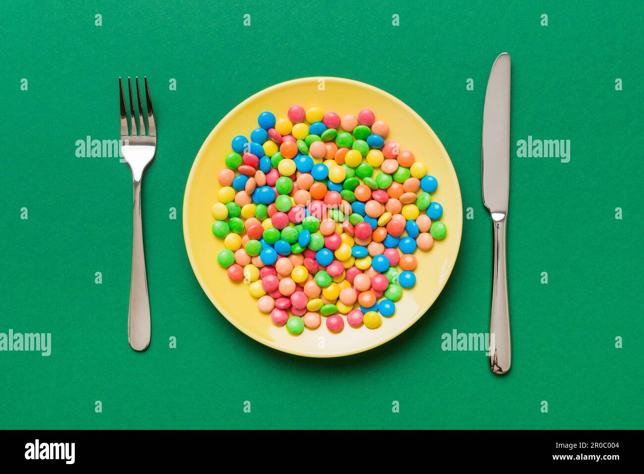 cutlery on table and sweet plate of candy. Health and obesity concept ...