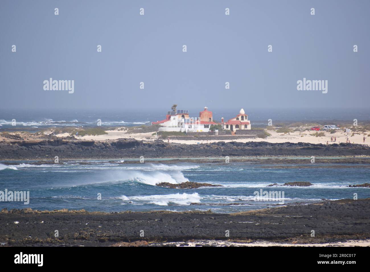 Waves crushing on the the bay near remote houses in El Cotillo ...