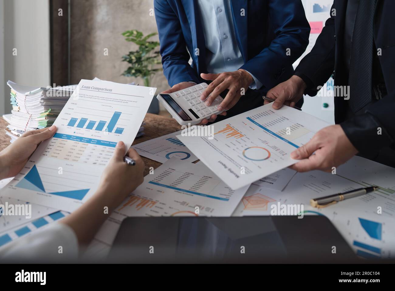 Business team using a calculator to calculate the numbers of statistic ...