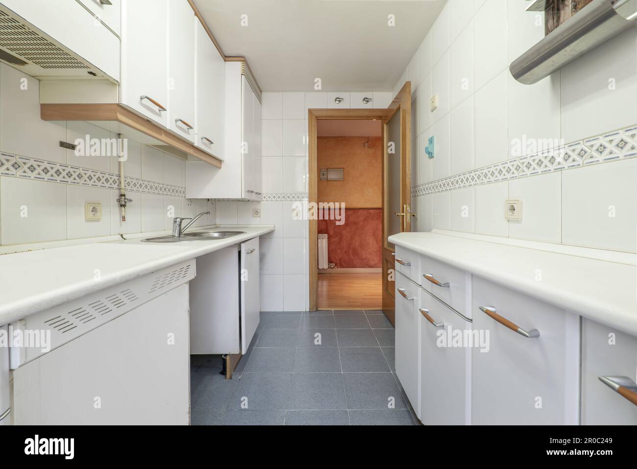 Kitchen furnished with white furniture and countertops of the same ...