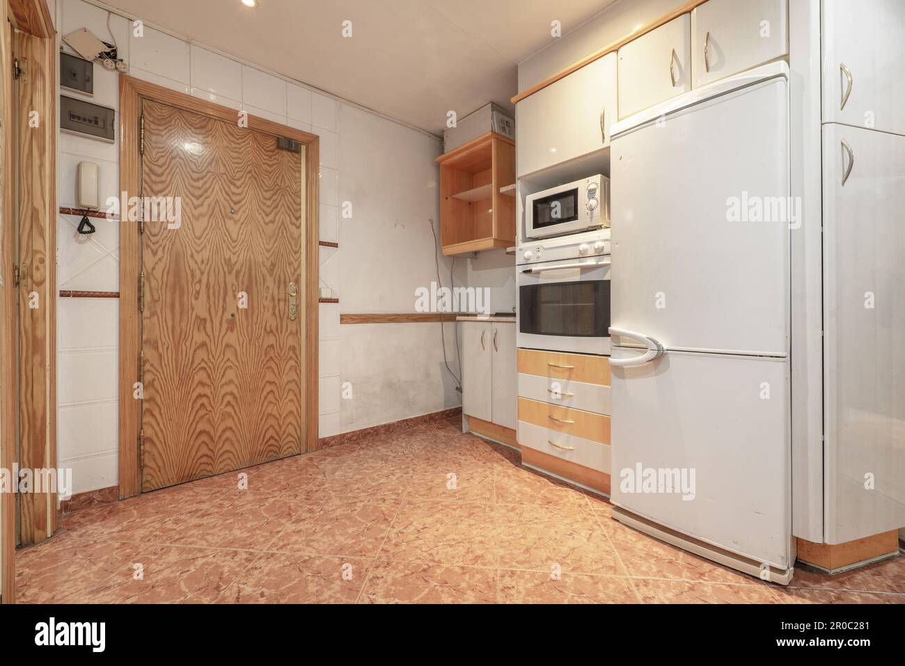 Kitchen furnished with white furniture and light-colored countertops ...