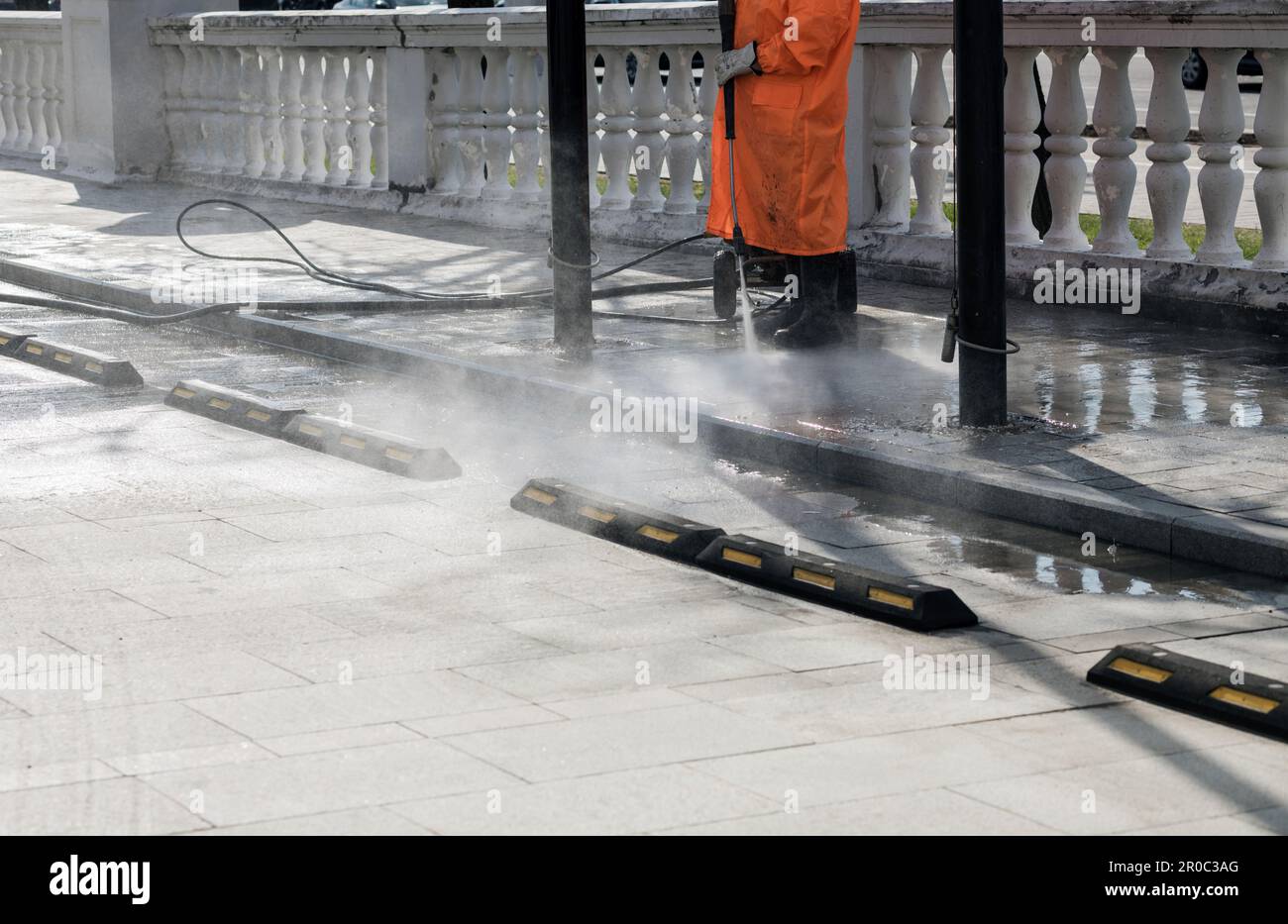 Outdoor floor cleaning with a pressure water jet. Worker cleaning a ...