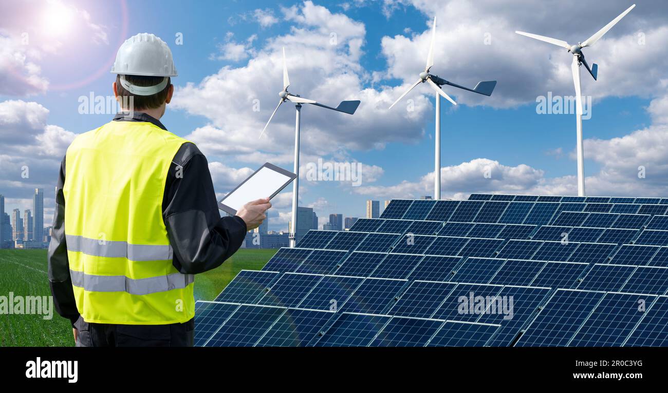 Worker with tablet computer on a background of wind turbines and solar ...